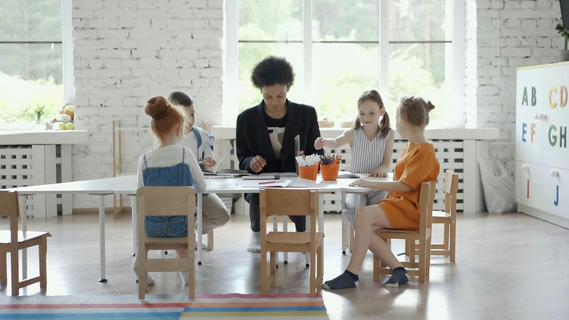 A Teacher Sitting with Her Students · Free Stock Video