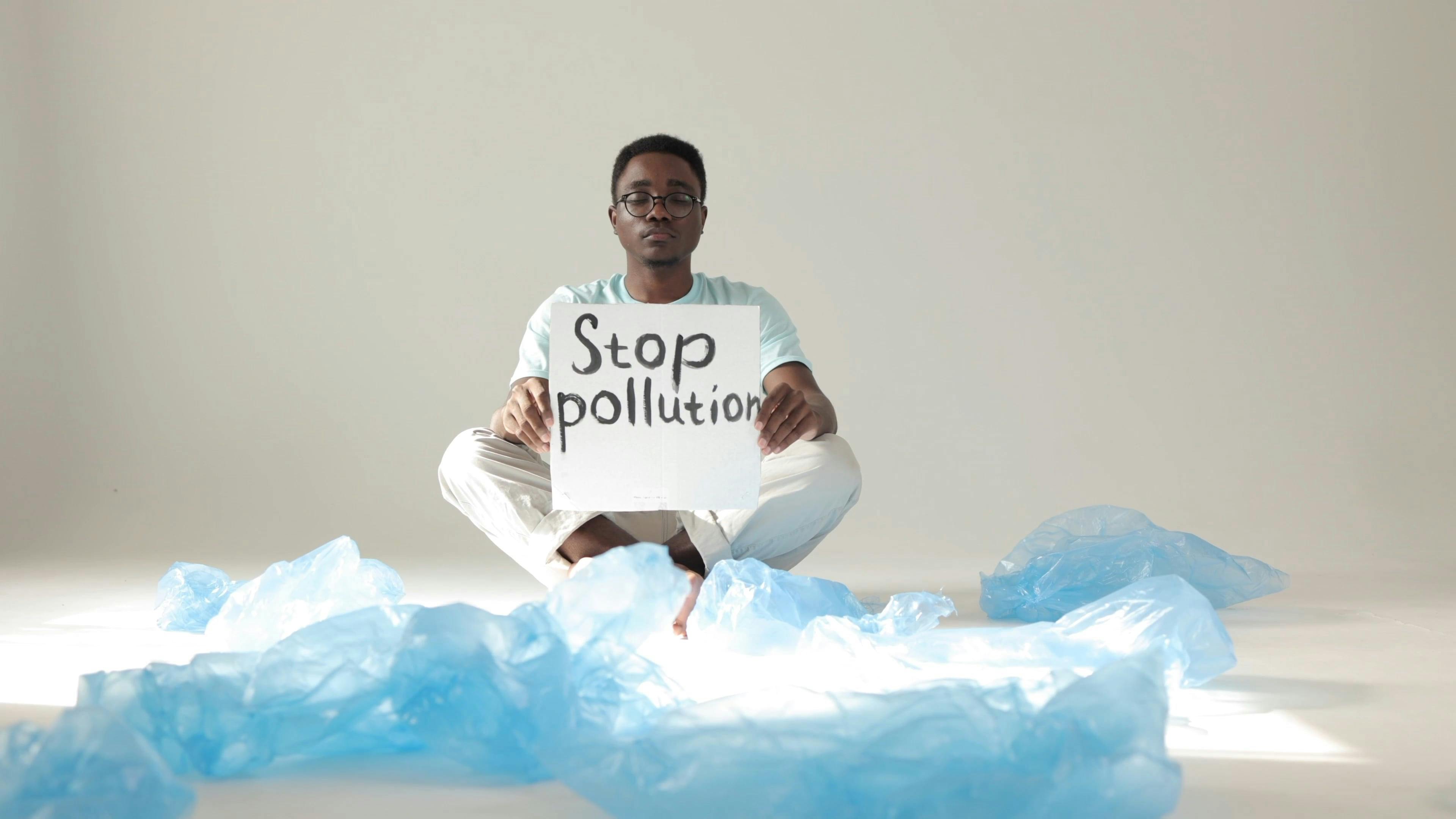 A Man Holding a Stop Pollution Placard on the Floor Free Stock Video ...