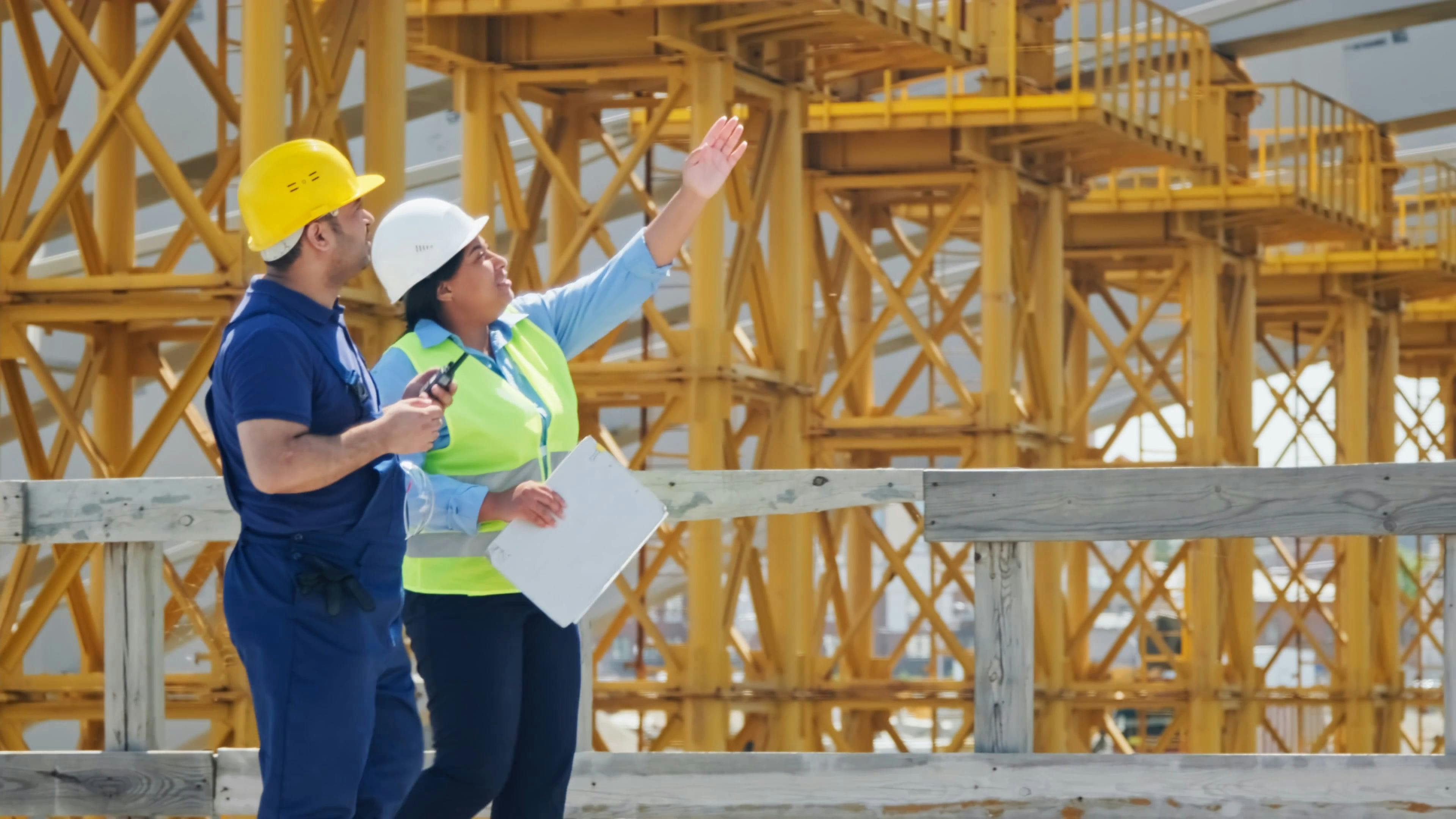 A Man and Woman Walking at the Construction Site · Free Stock Video