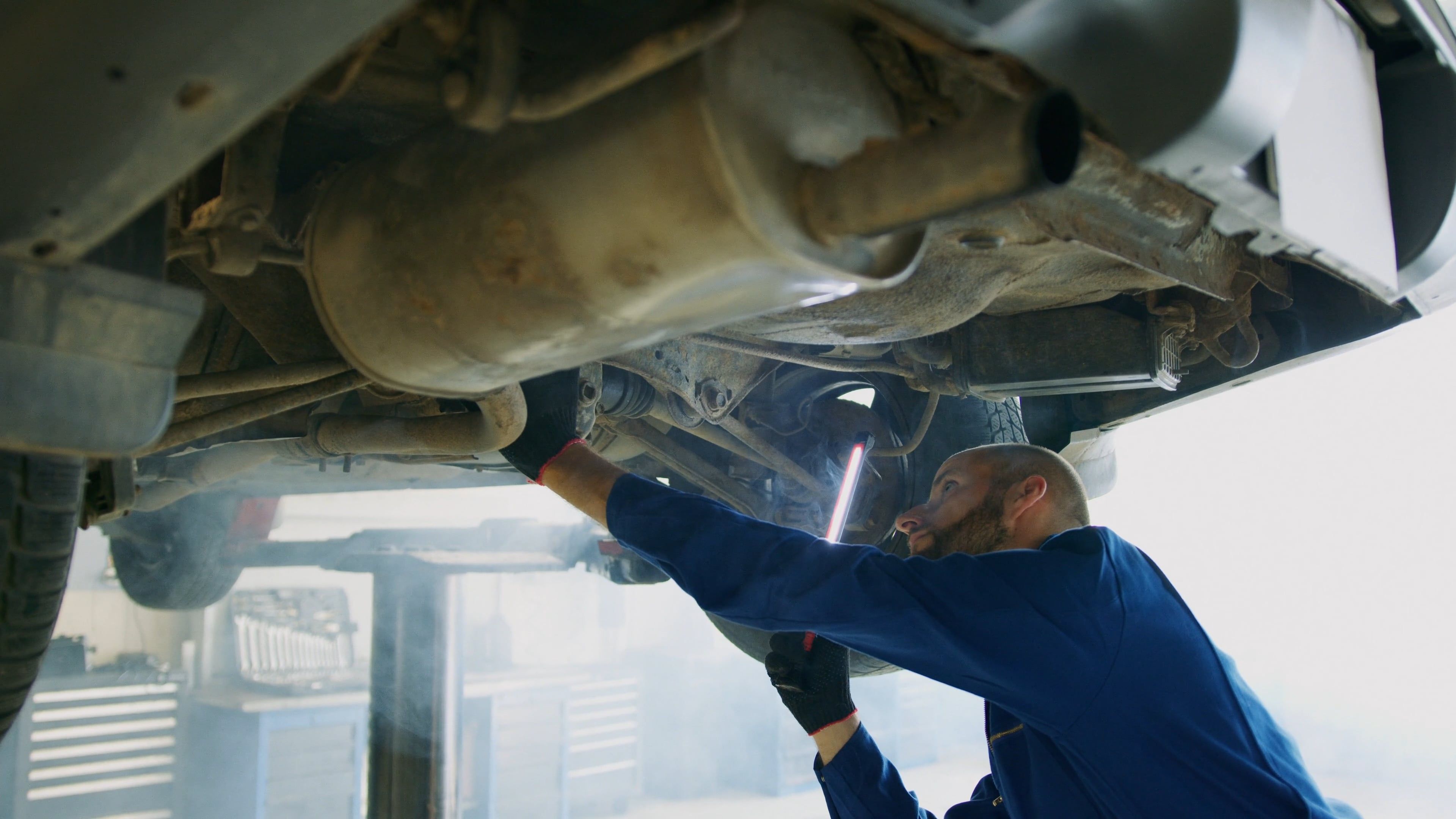 An Auto Mechanic Inspecting the Undercarrige of a Vehicle Free Stock ...