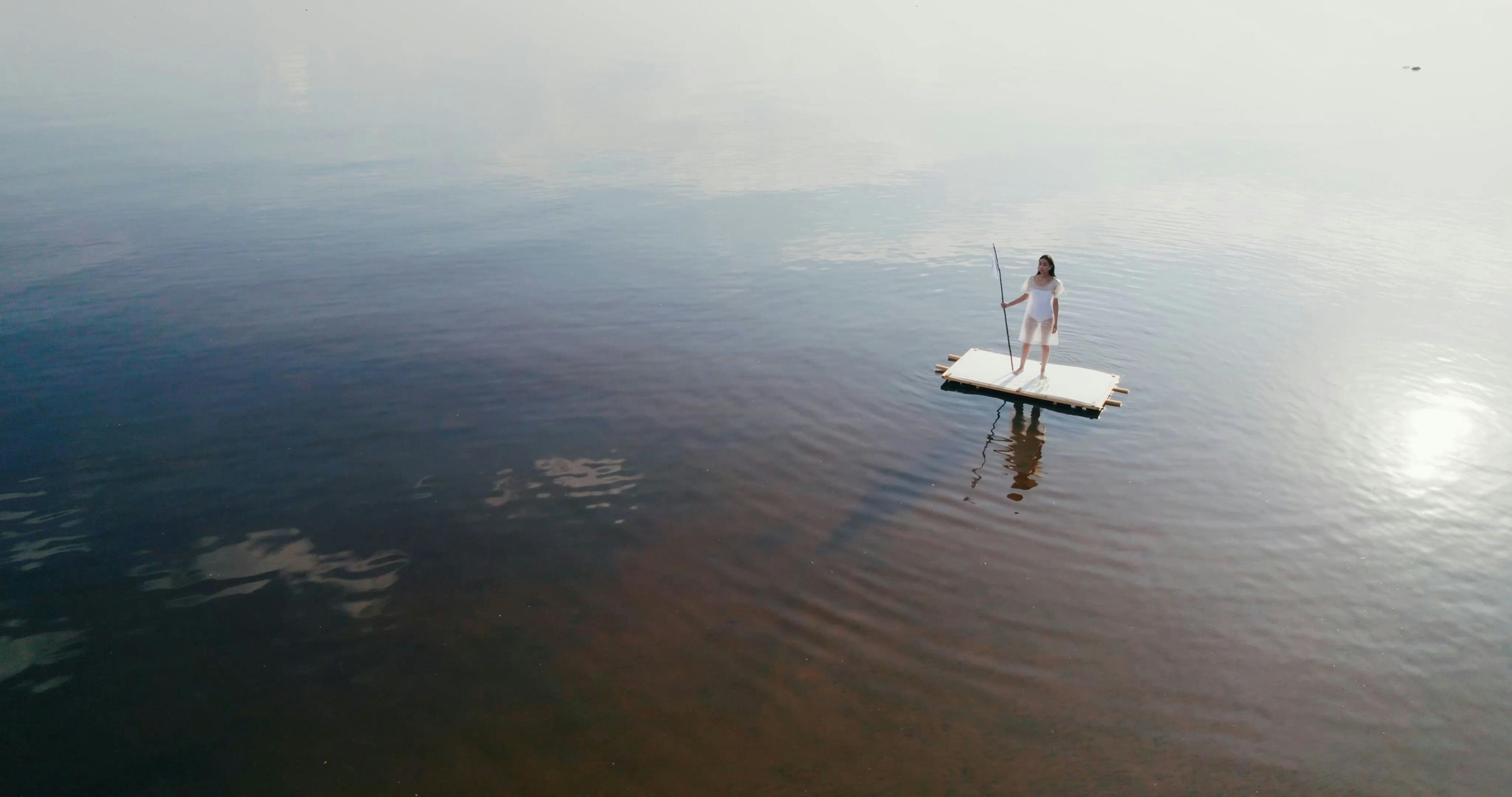 A Woman Holding a White Flag While Standing on a Raft Free Stock Video ...