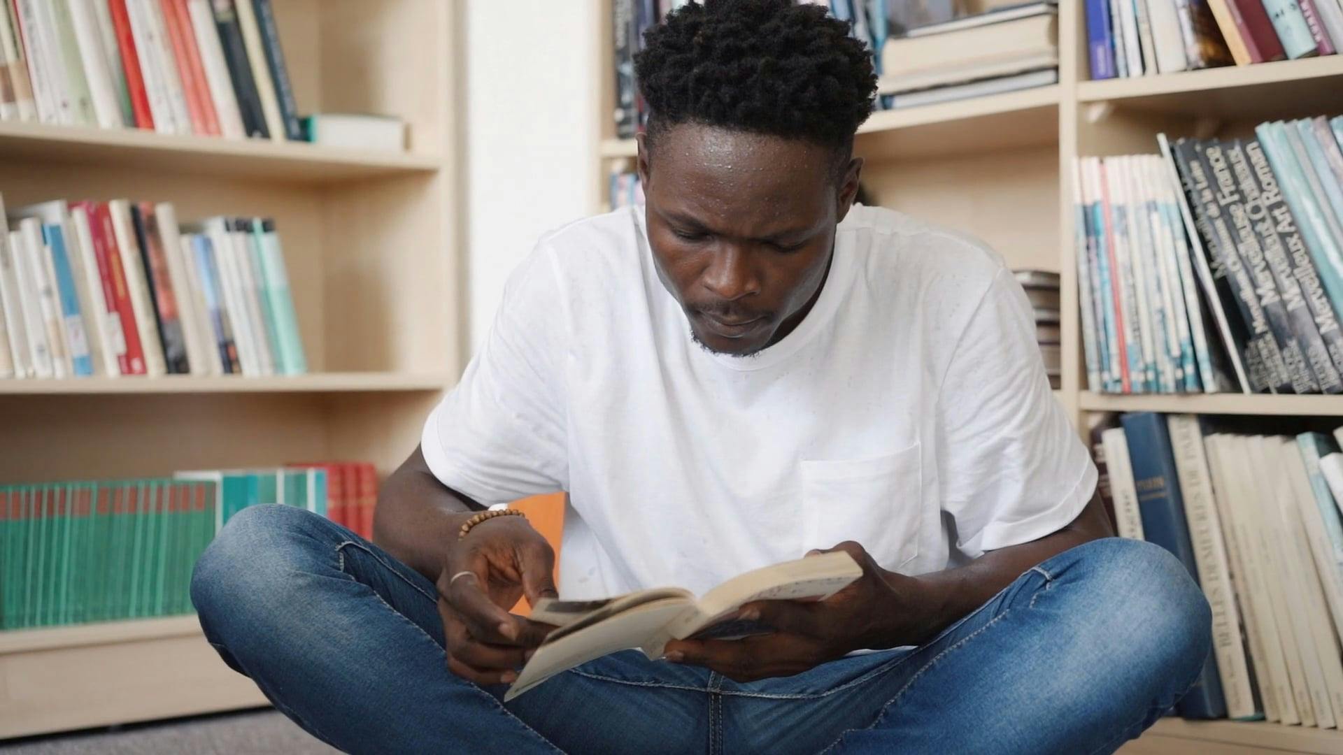 A Man Scanning the Pages of Books While Sitting on the Floor Free Stock ...