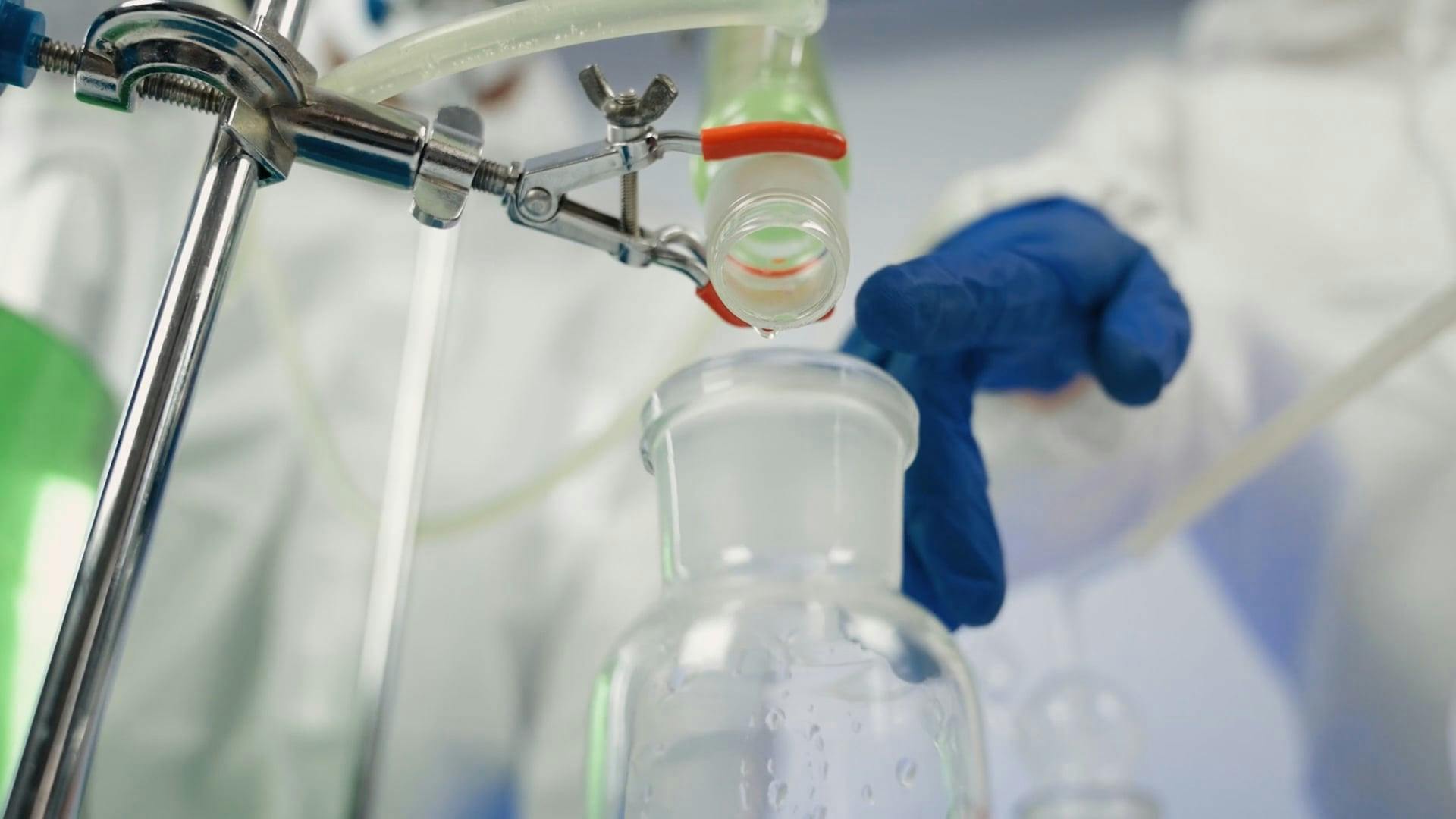 Drops of Liquid from a Tube Falling into a Flask · Free Stock Video