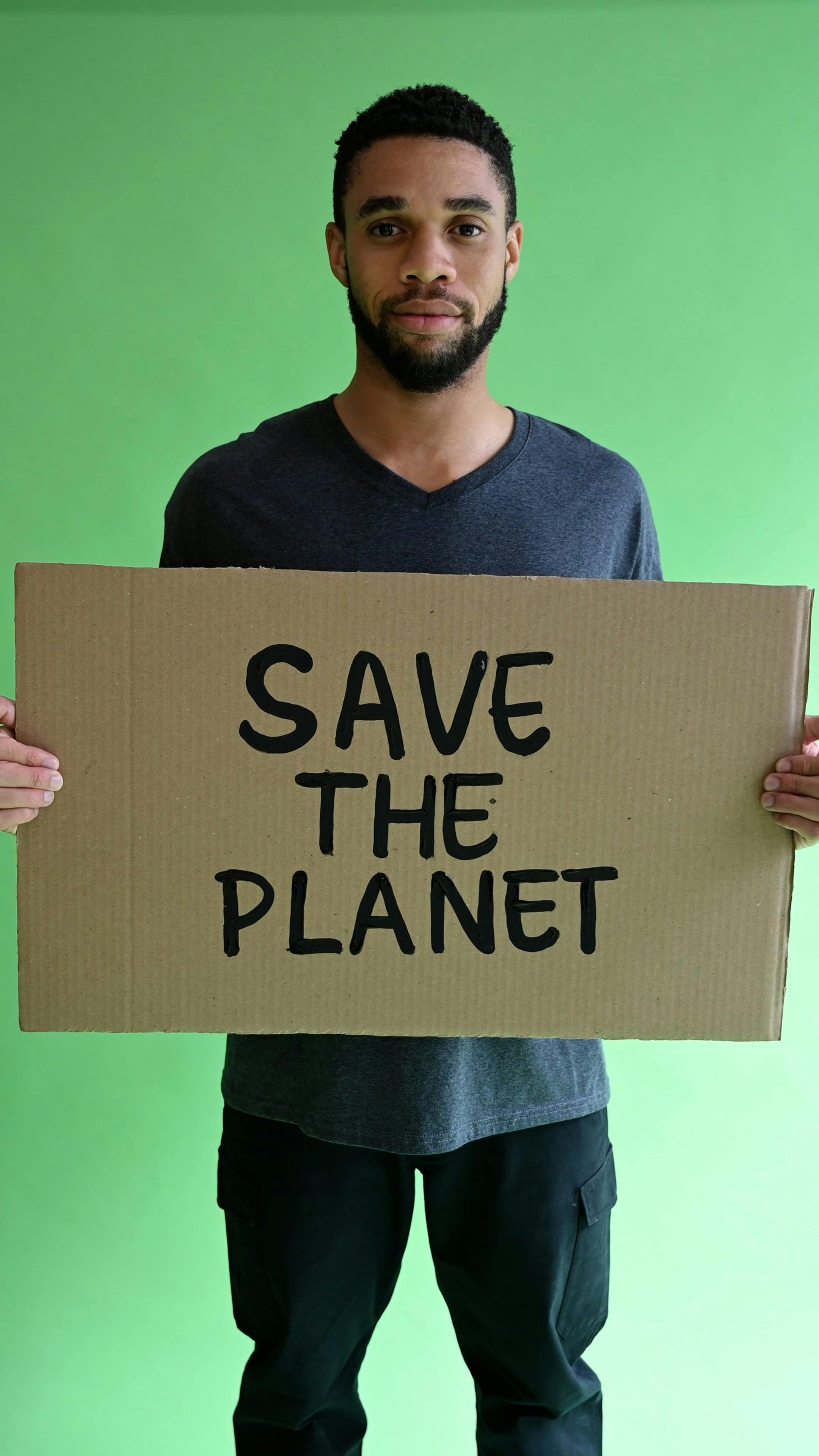 A man holding a sign that says save the planet Free Stock Video Footage ...