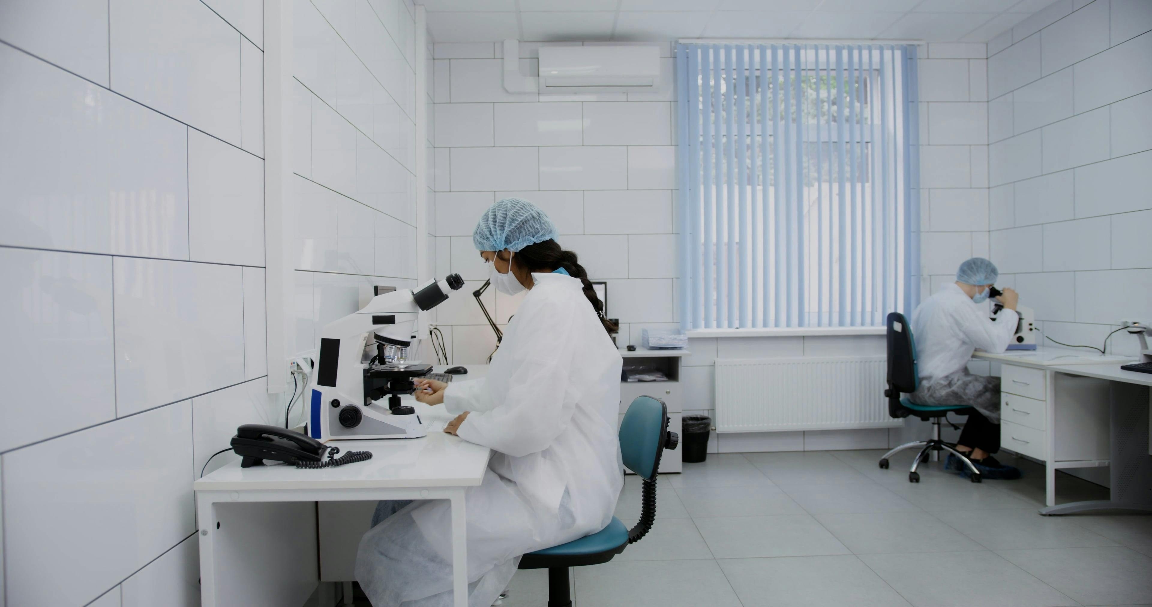 A Woman Writing while Looking at the Microscope Free Stock Video ...