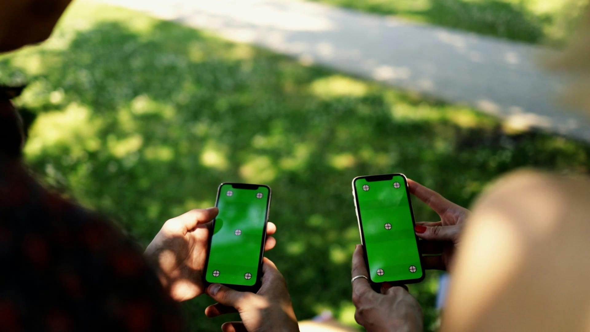 Two people holding smart phones with green screens Free Stock Video ...