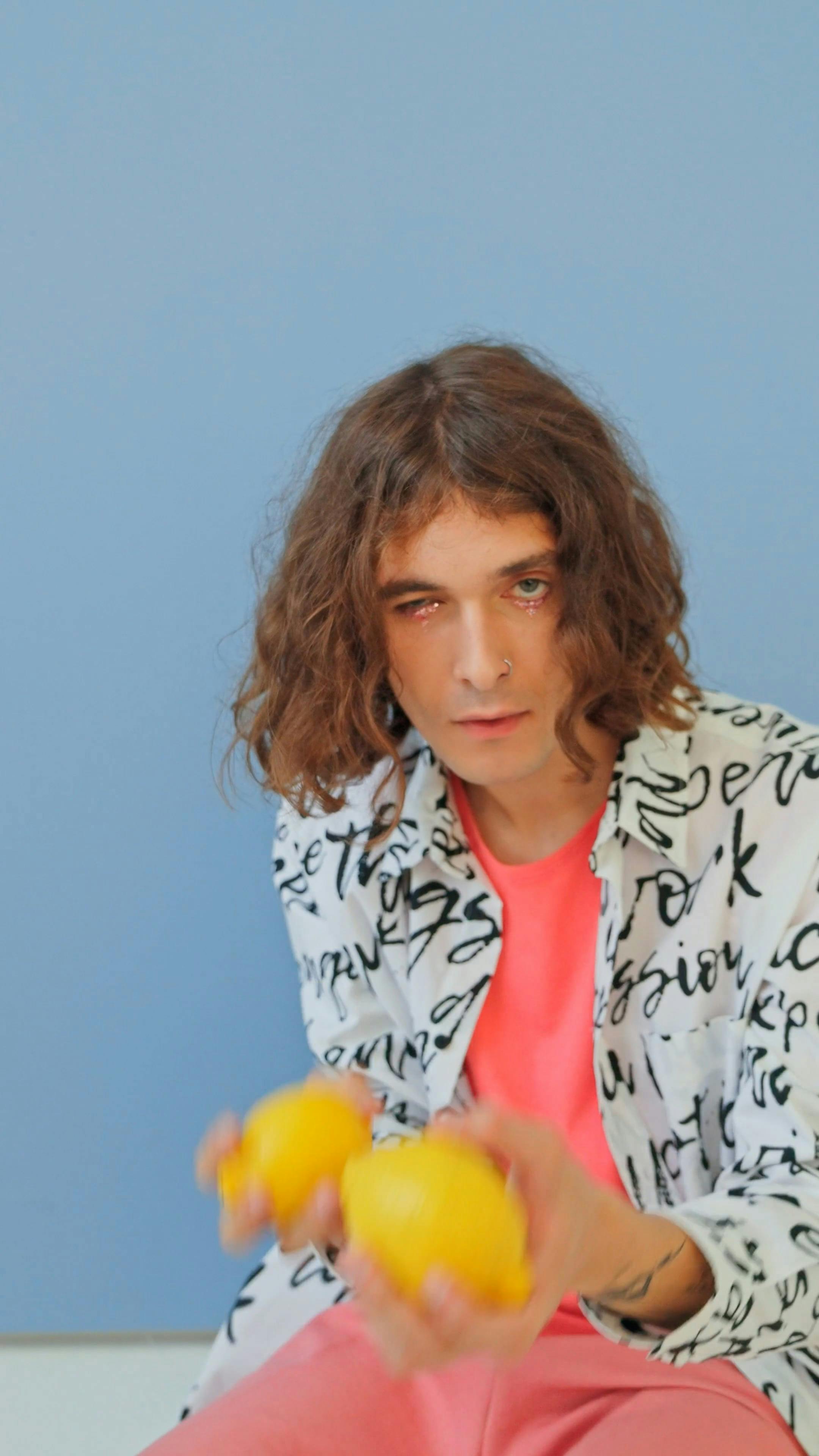 Male model juggling lemons against blue background Free Stock Video ...