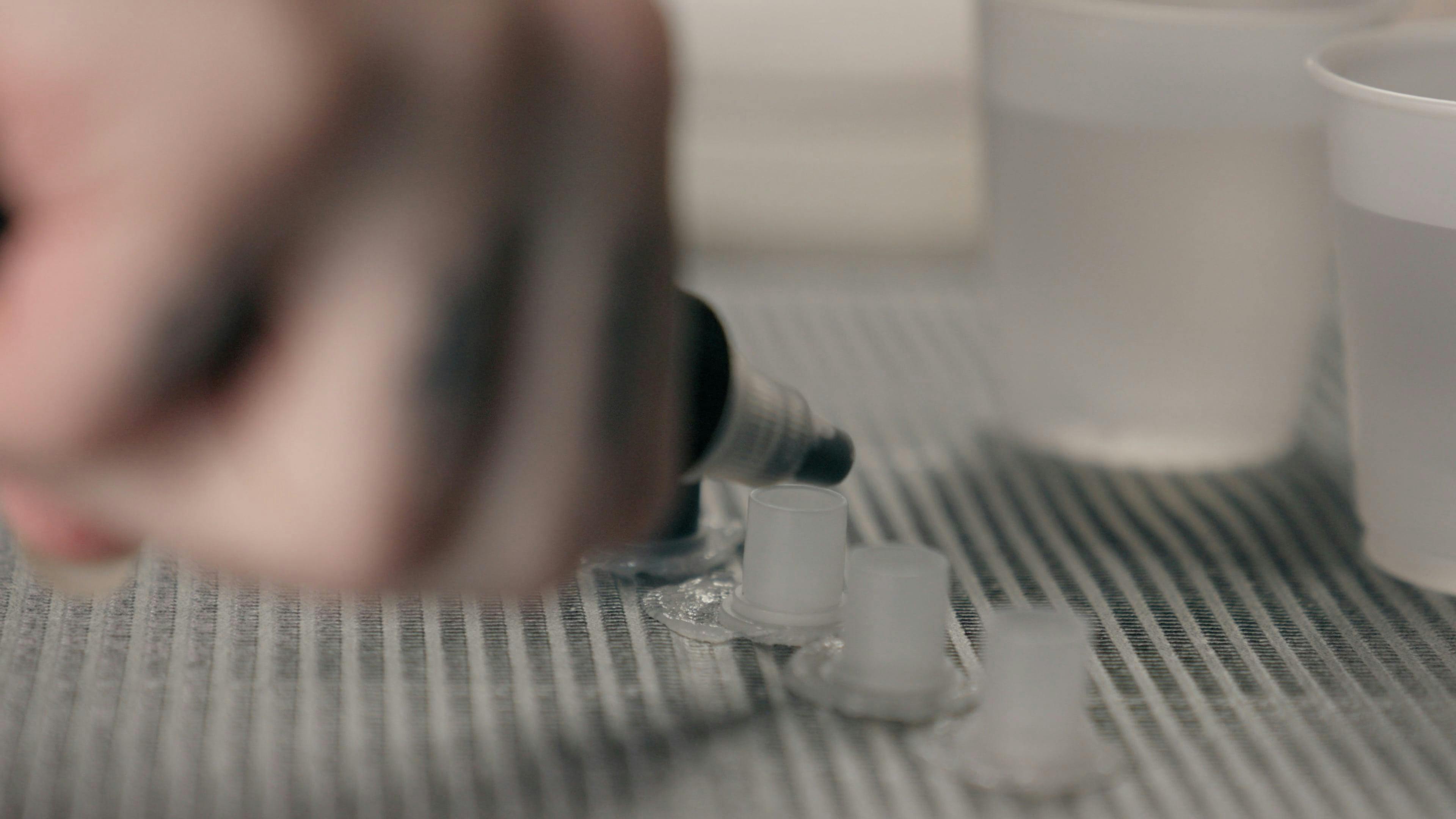 Tattoo artist pouring ink into small cups · Free Stock Video