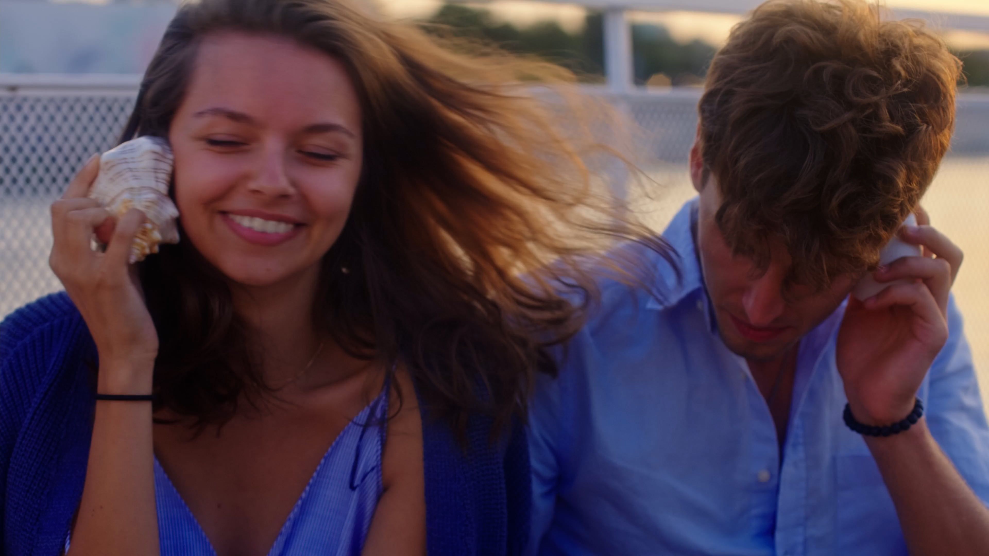 A Man and a Woman Holding Sea Shells to their Ears Free Stock Video ...