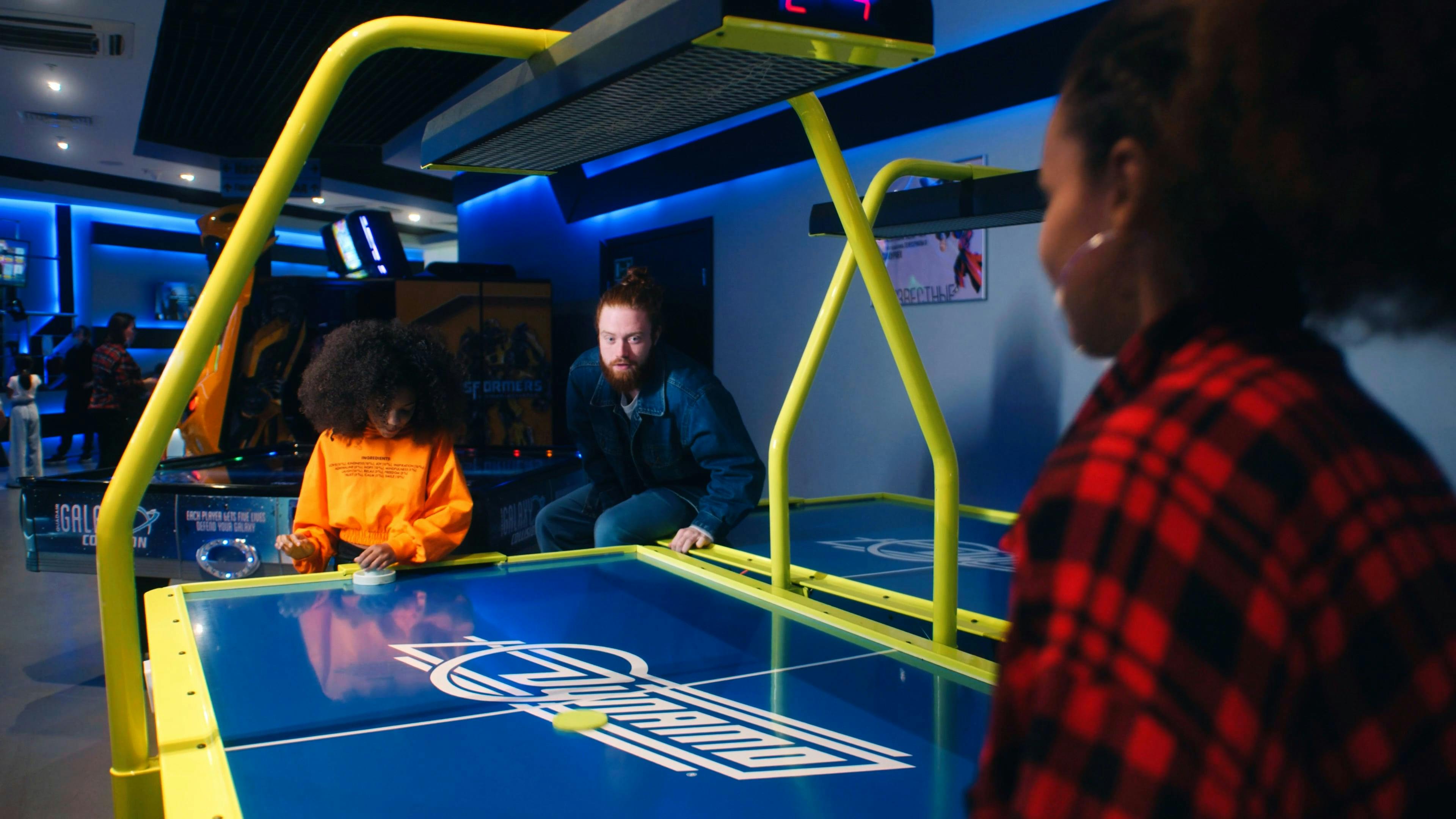 A Happy Family Playing Air Hockey in an Amusement Arcade Free Stock ...